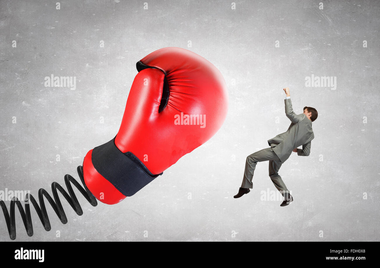 Young determined businessman fighting boxing glove on spring Stock ...