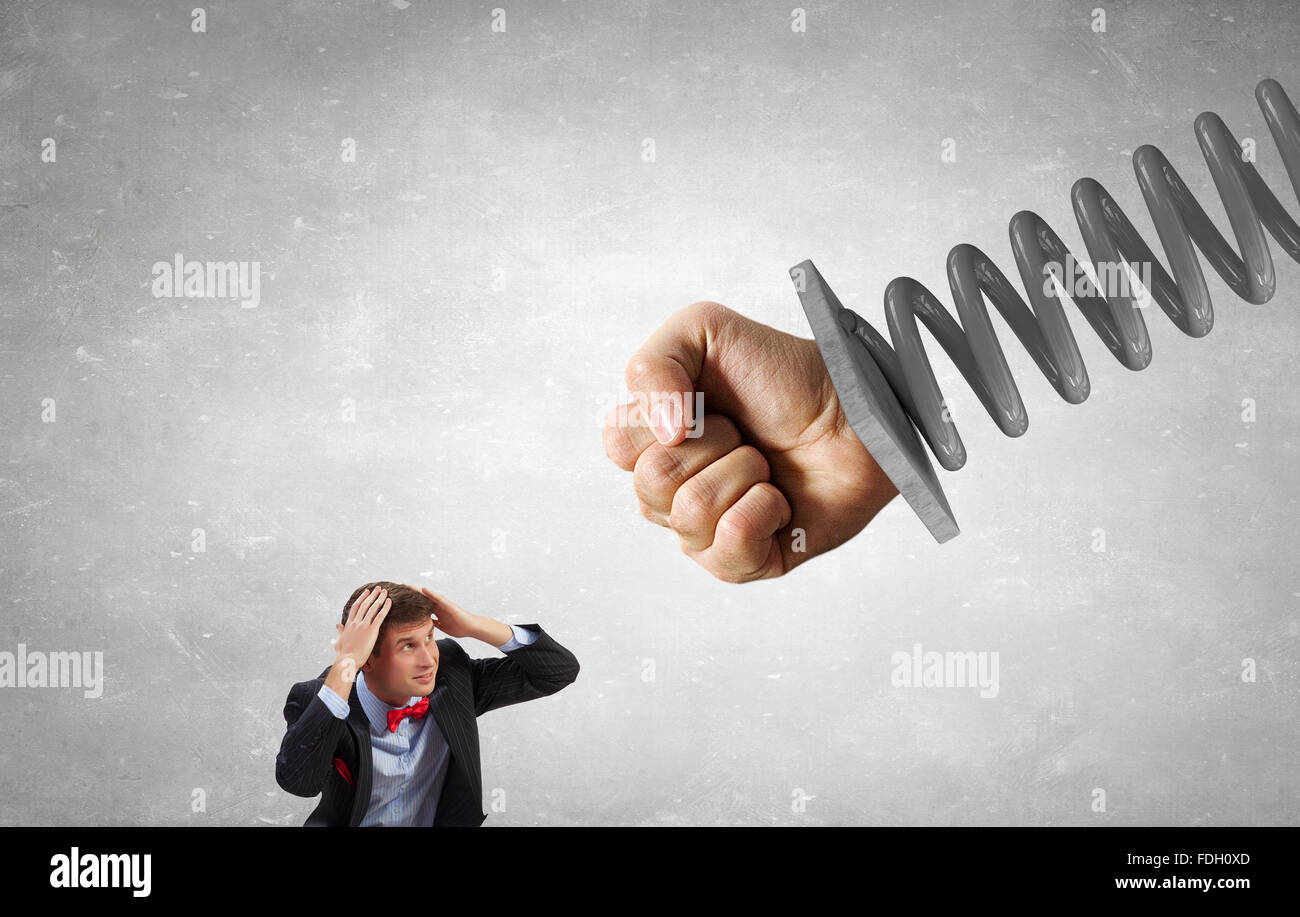 Young determined businessman fighting with human fist on spring Stock ...