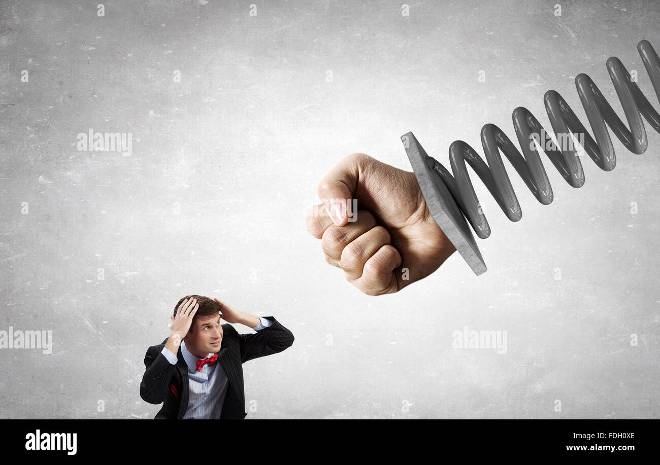 Young determined businessman fighting with human fist on spring Stock ...