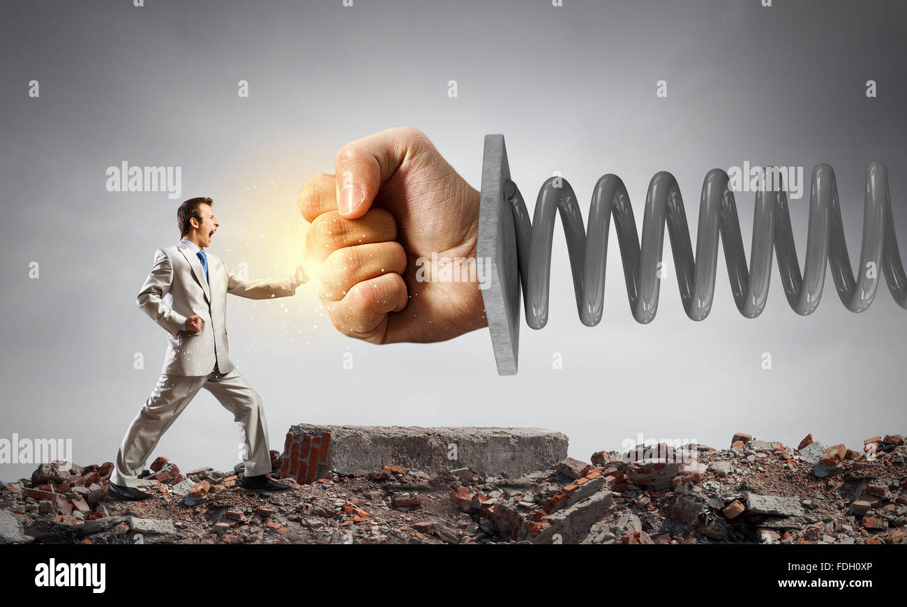 Young determined businessman fighting with human fist on spring Stock ...
