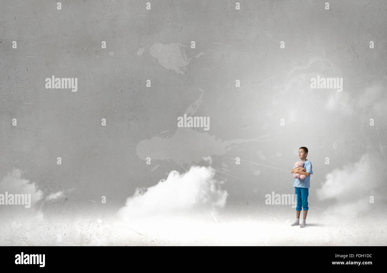 Cute little boy with toy bear on cloud background Stock Photo - Alamy