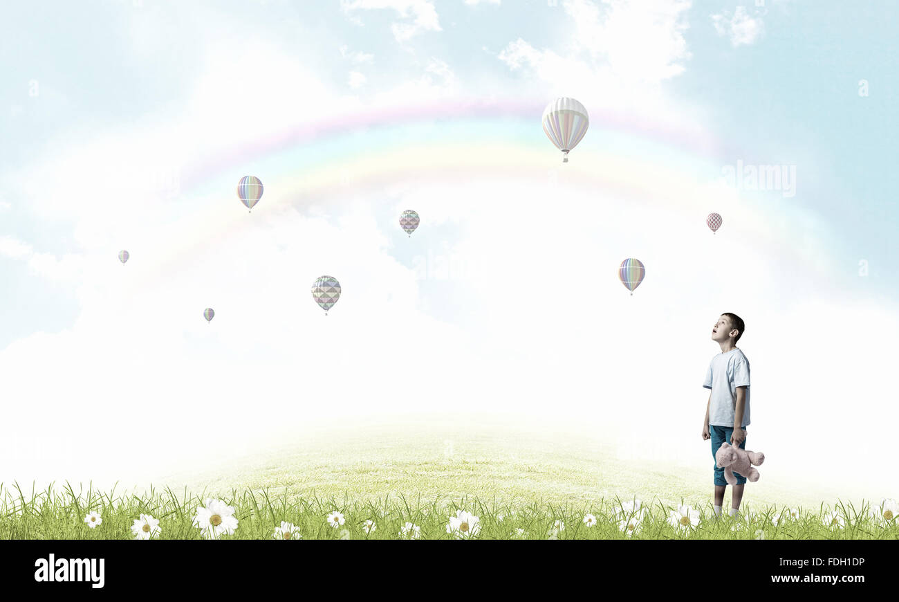 Cute little boy with toy bear on cloud background Stock Photo - Alamy