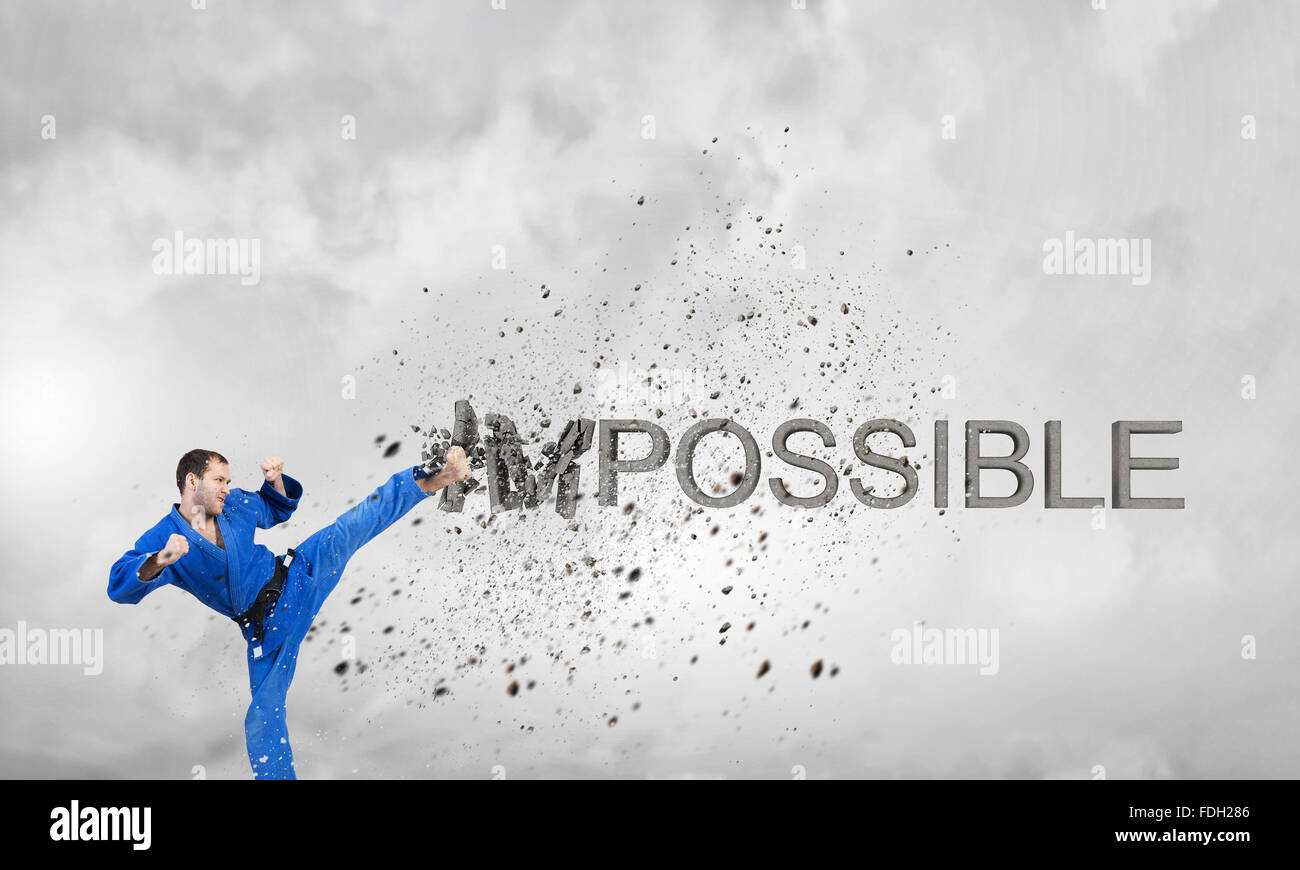 Young determined karate man breaking stone impossible word Stock Photo ...