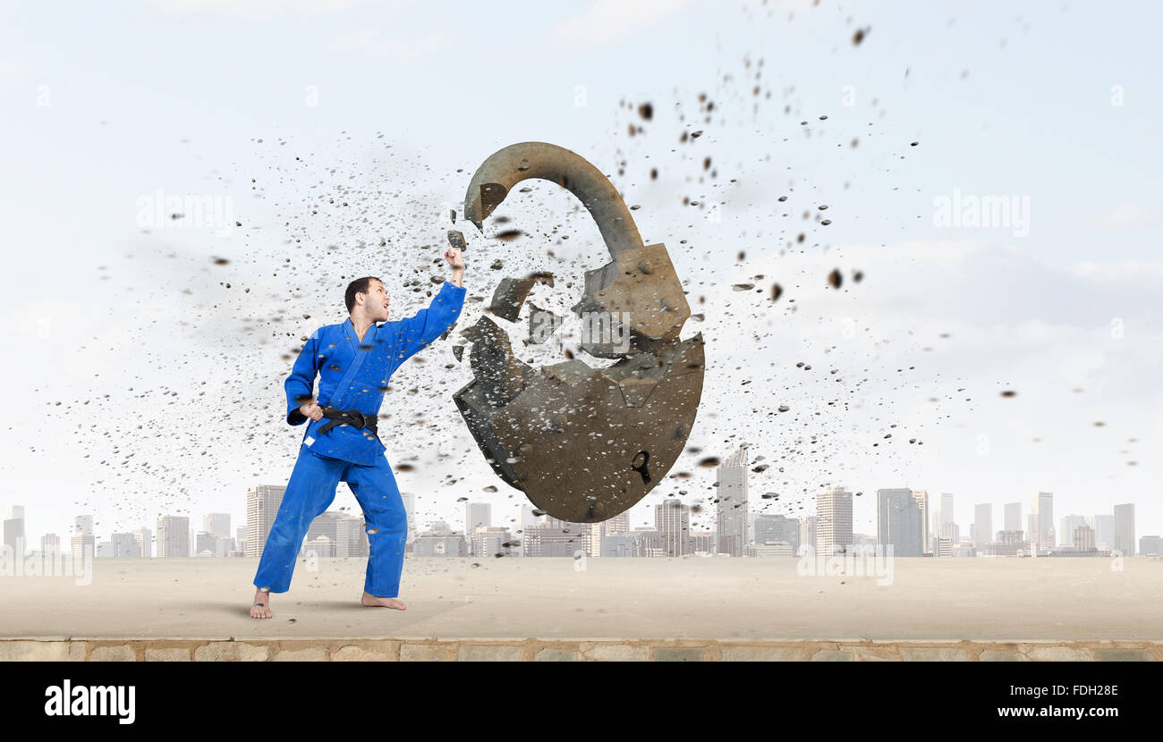 Young determined karate man breaking with anger concrete lock Stock ...