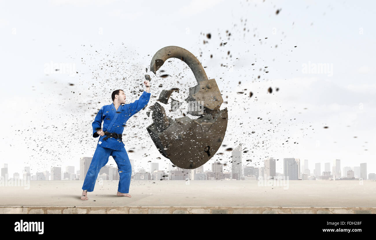 Young determined karate man breaking with anger concrete lock Stock ...