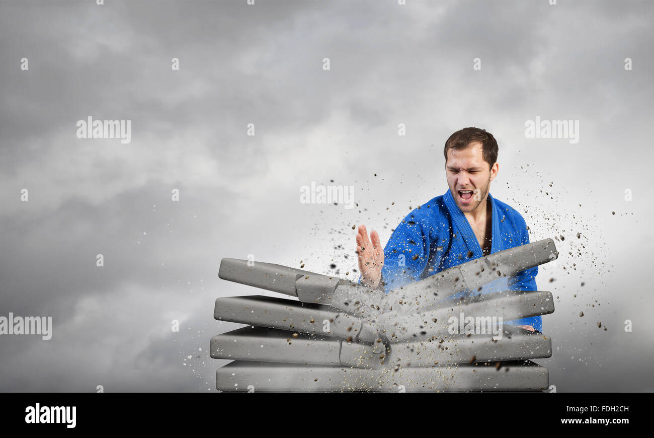 Young determined karate man breaking with hand concrete bricks Stock ...