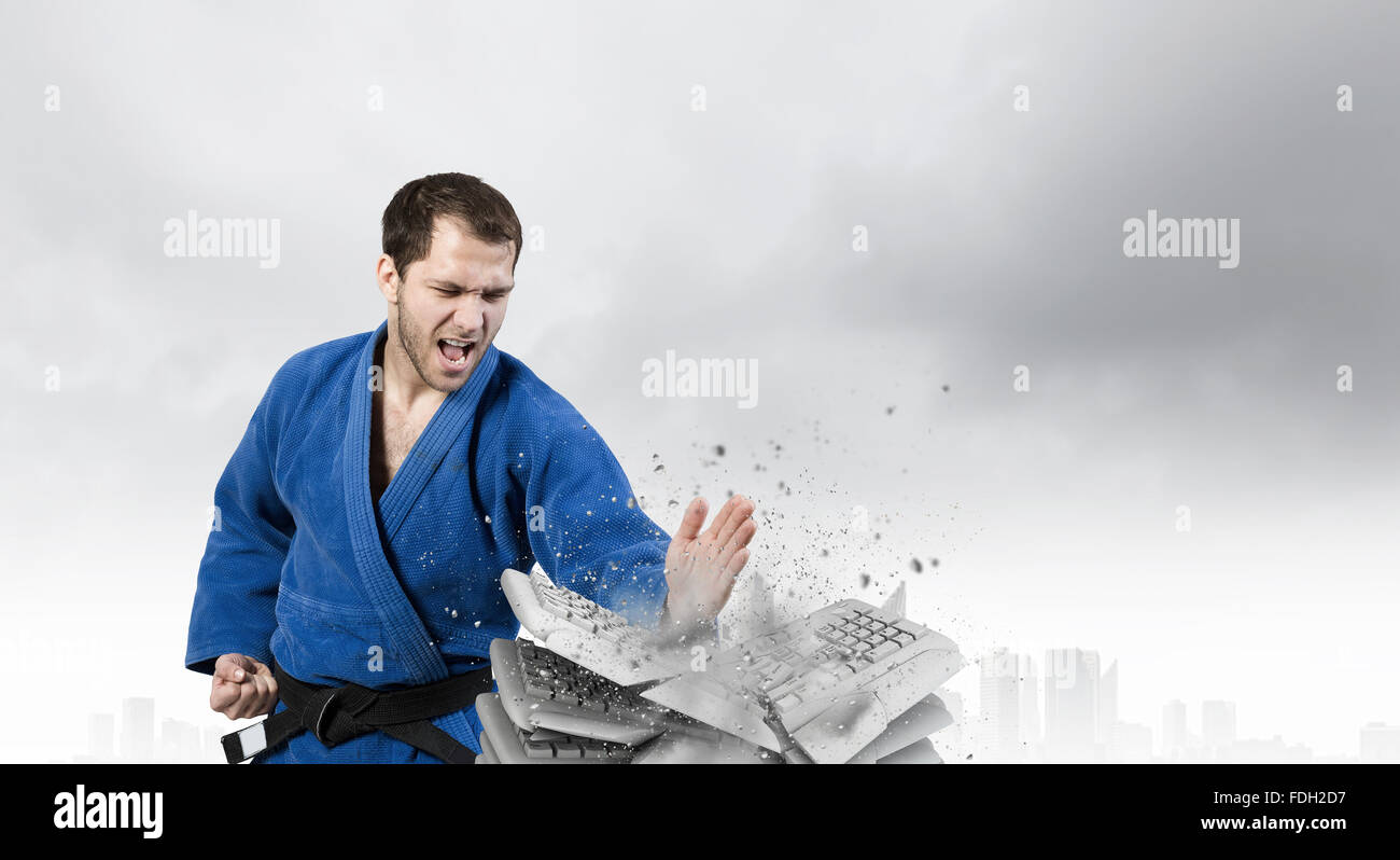 Young determined karate man breaking with hand concrete bricks Stock ...