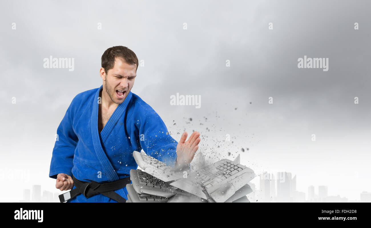 Young determined karate man breaking with hand concrete bricks Stock ...