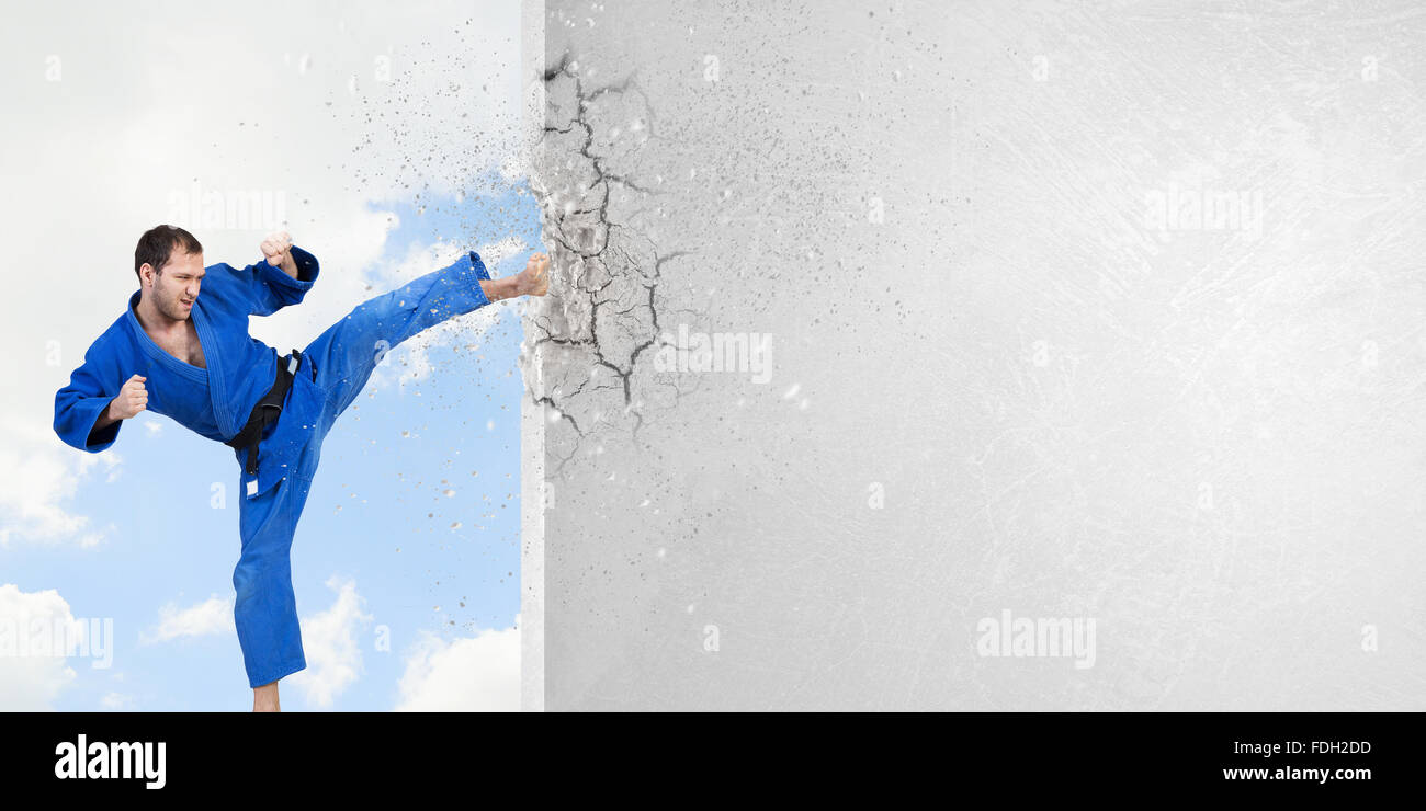 Young determined karate man breaking with leg concrete wall Stock Photo ...