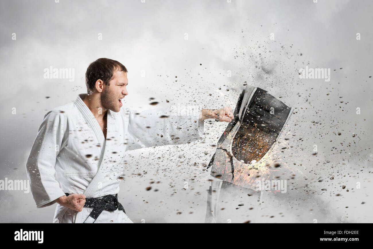 Young determined karate man breaking personal computer Stock Photo - Alamy