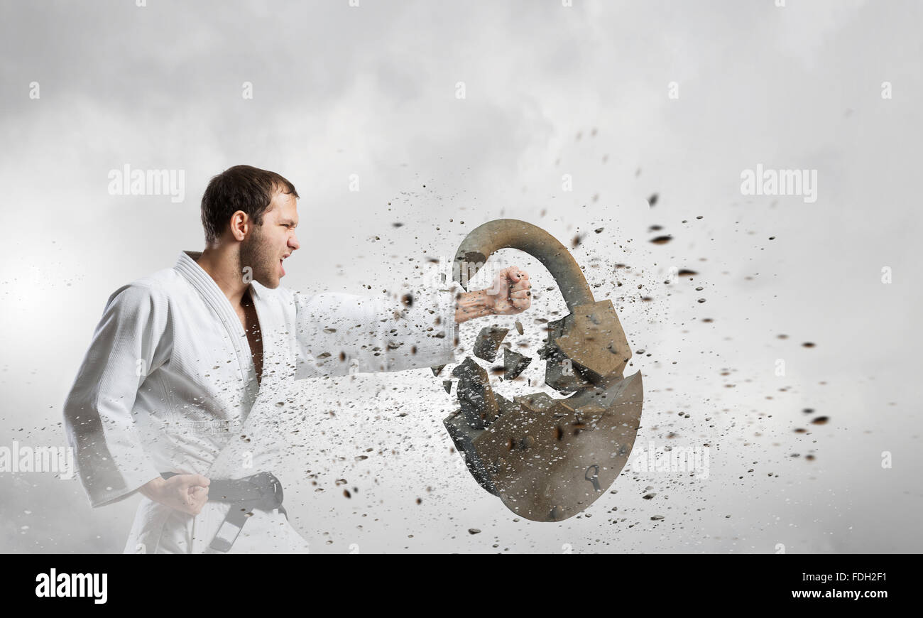 Young determined karate man breaking with anger concrete lock Stock ...