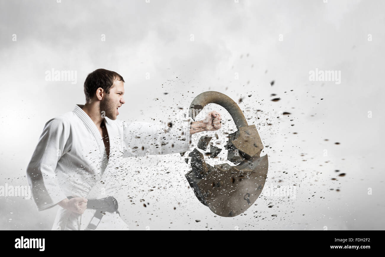 Young determined karate man breaking with anger concrete lock Stock ...