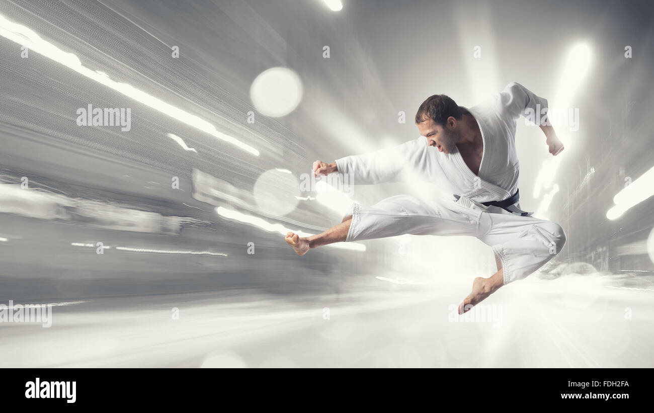 Young determined karate man jumping high in hit Stock Photo - Alamy