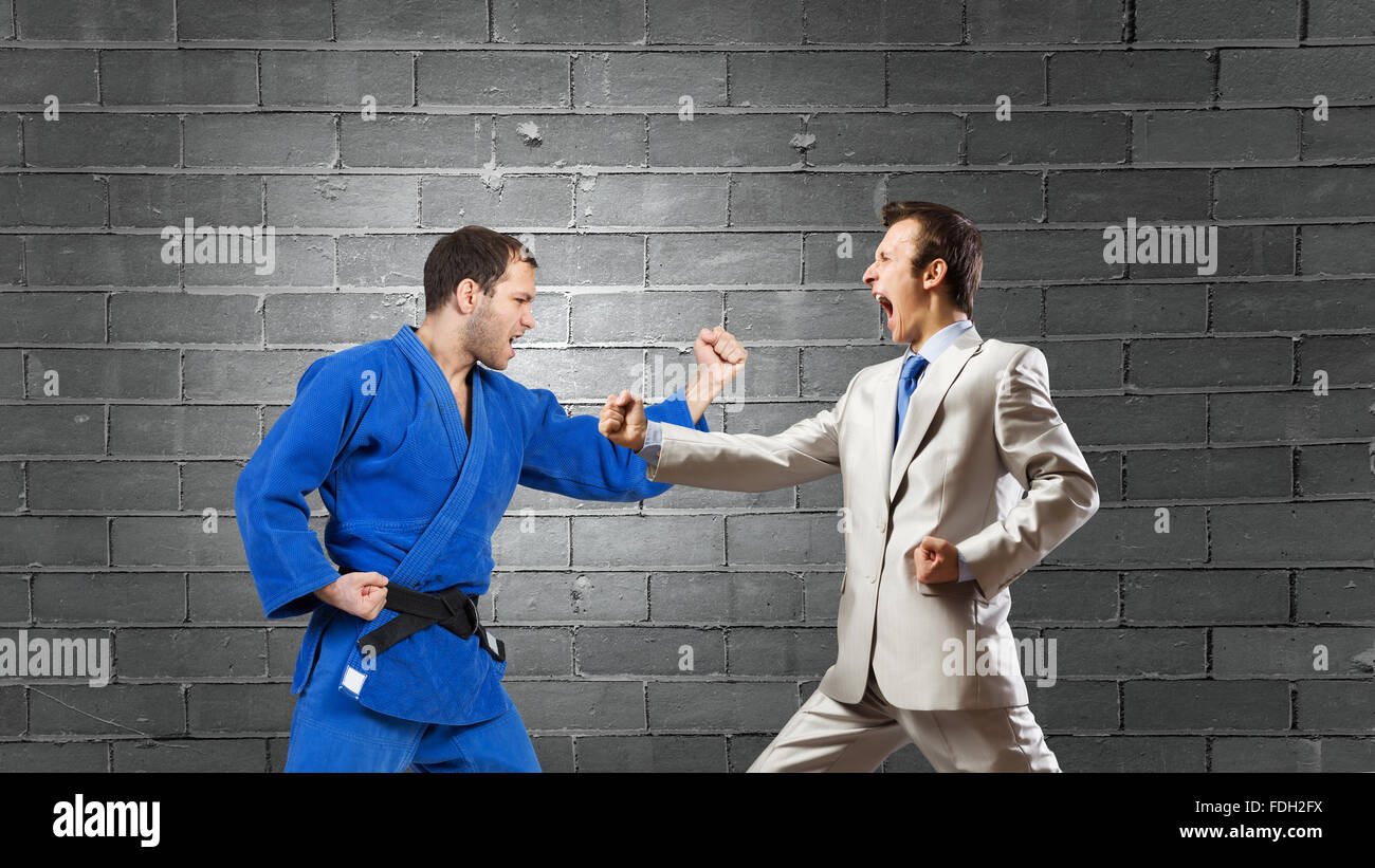 Young determined karate man fighting with businessman in suit Stock ...