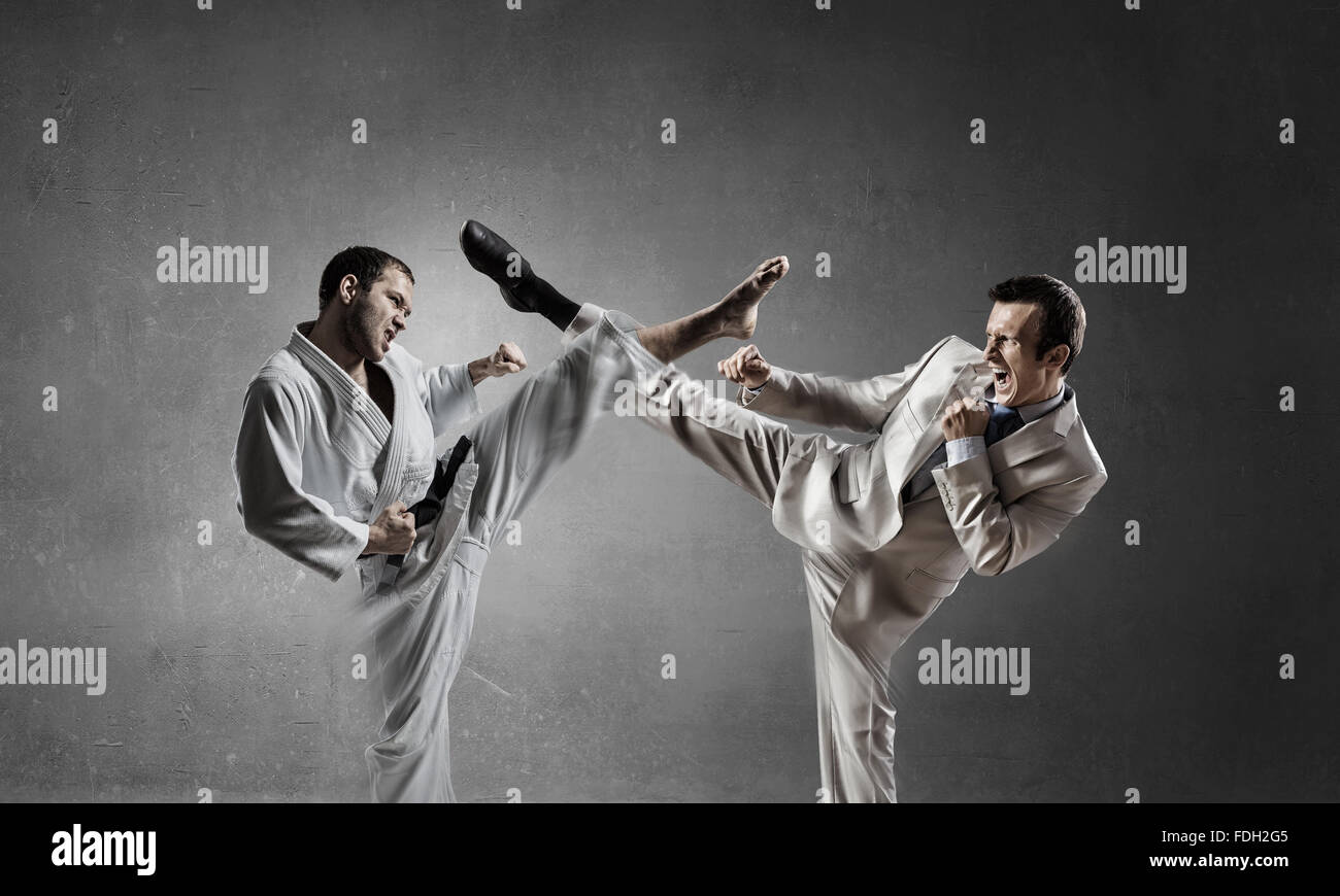 Young determined karate man fighting with businessman in suit Stock ...