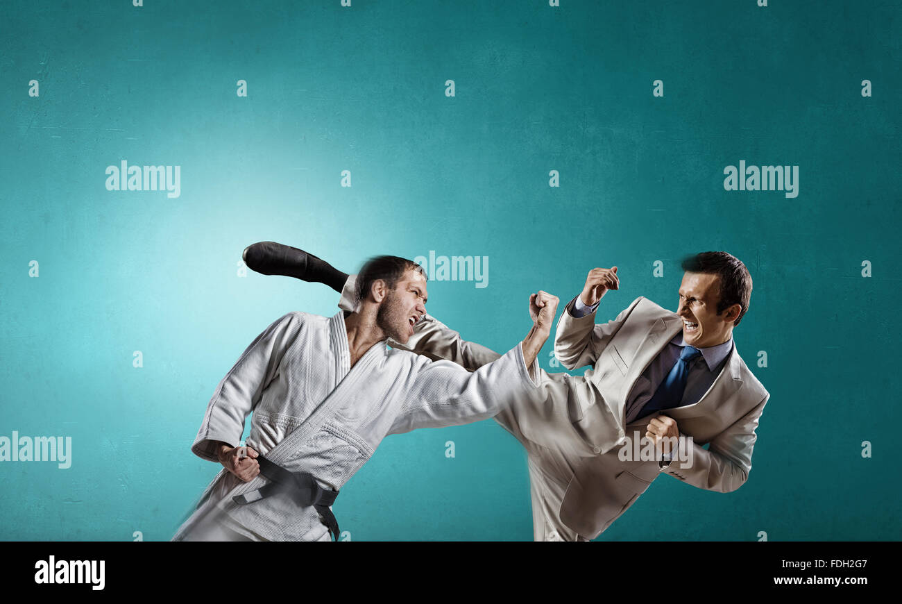 Young determined karate man fighting with businessman in suit Stock ...