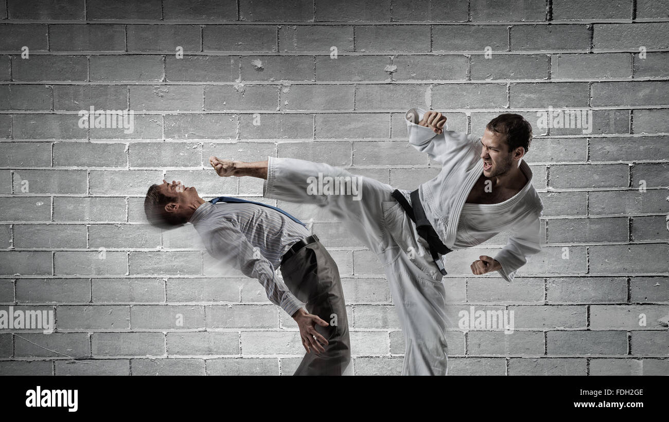 Young determined karate man fighting with businessman in suit Stock ...