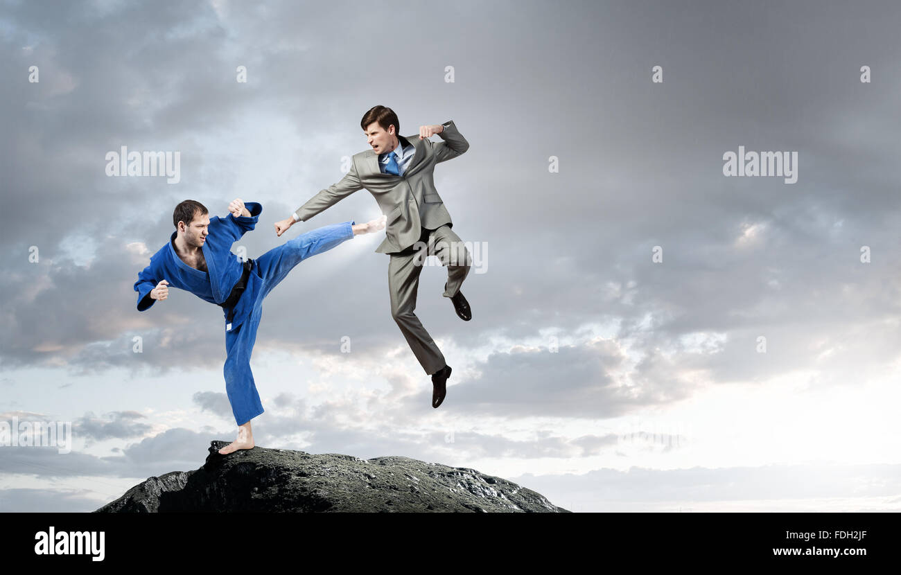 Young determined karate man fighting with businessman in suit Stock ...