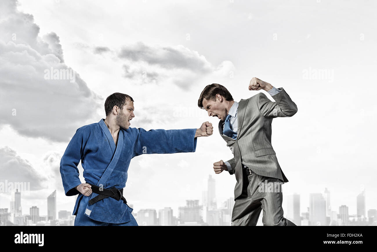 Young determined karate man fighting with businessman in suit Stock ...