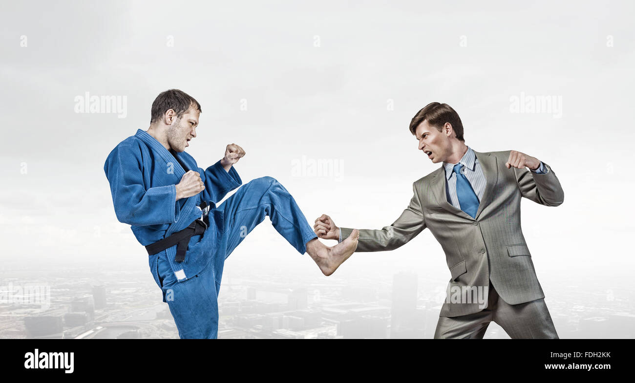Young determined karate man fighting with businessman in suit Stock ...