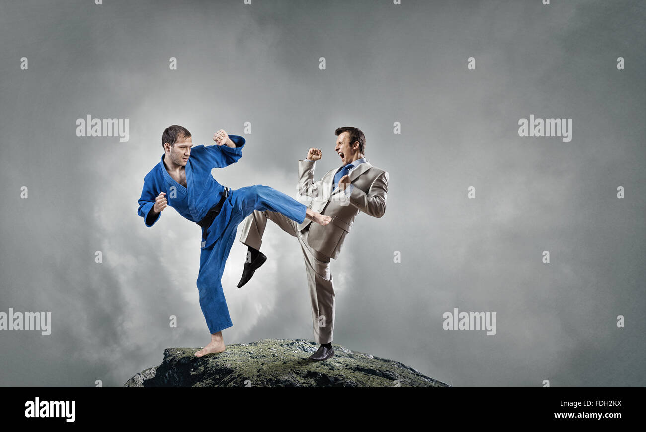 Young determined karate man fighting with businessman in suit Stock ...
