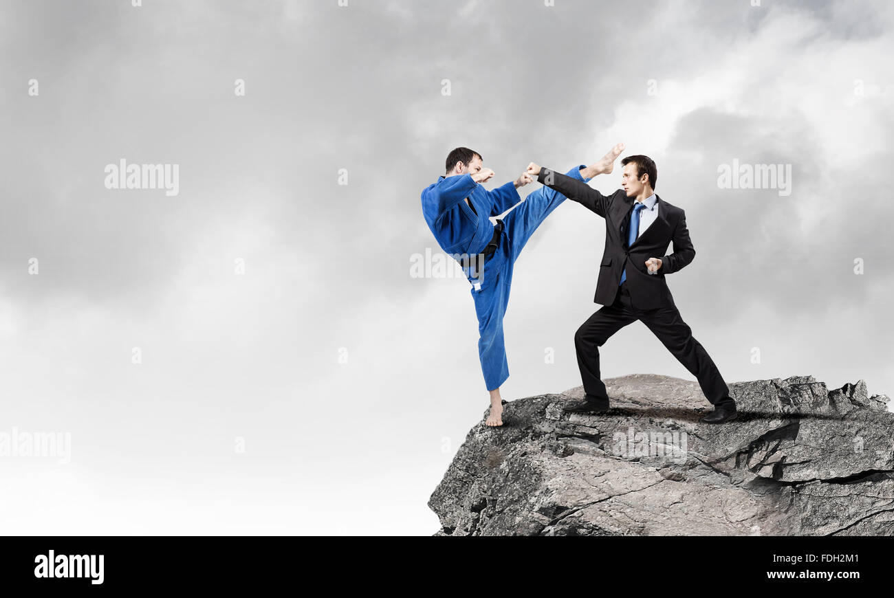 Young determined karate man fighting with businessman in suit Stock ...
