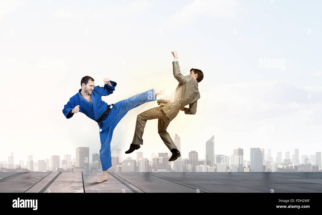 Young determined karate man fighting with businessman in suit Stock ...