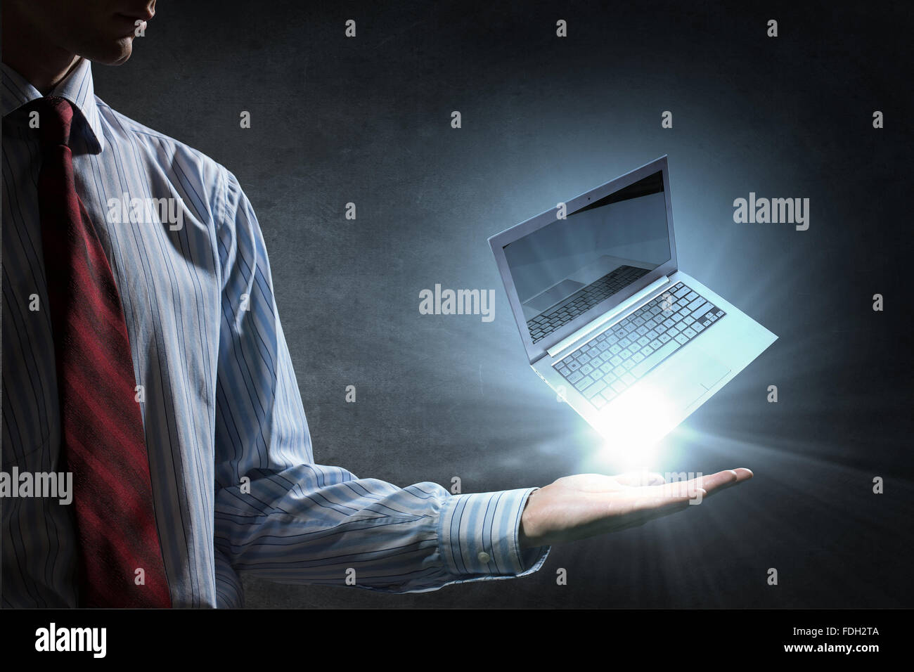 Human hand holding in palm glowing laptop Stock Photo - Alamy
