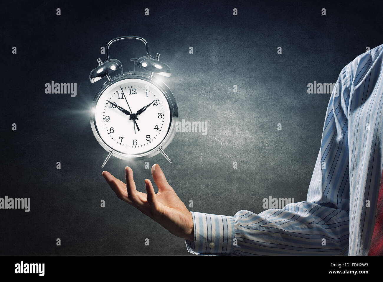 Close up image of human hand holding alarm clock Stock Photo - Alamy