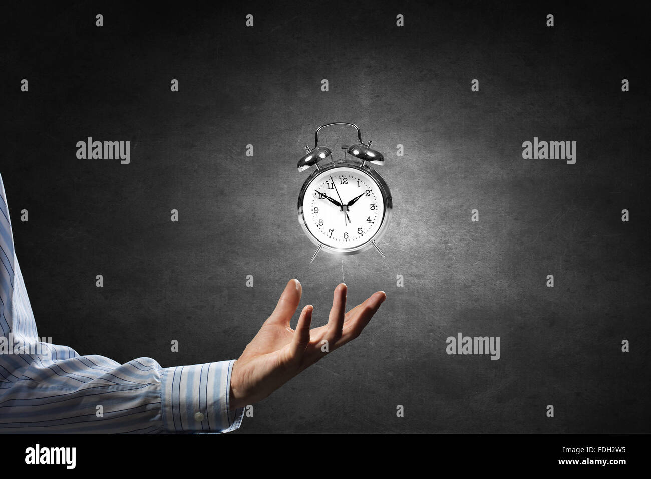 Close up image of human hand holding alarm clock Stock Photo - Alamy