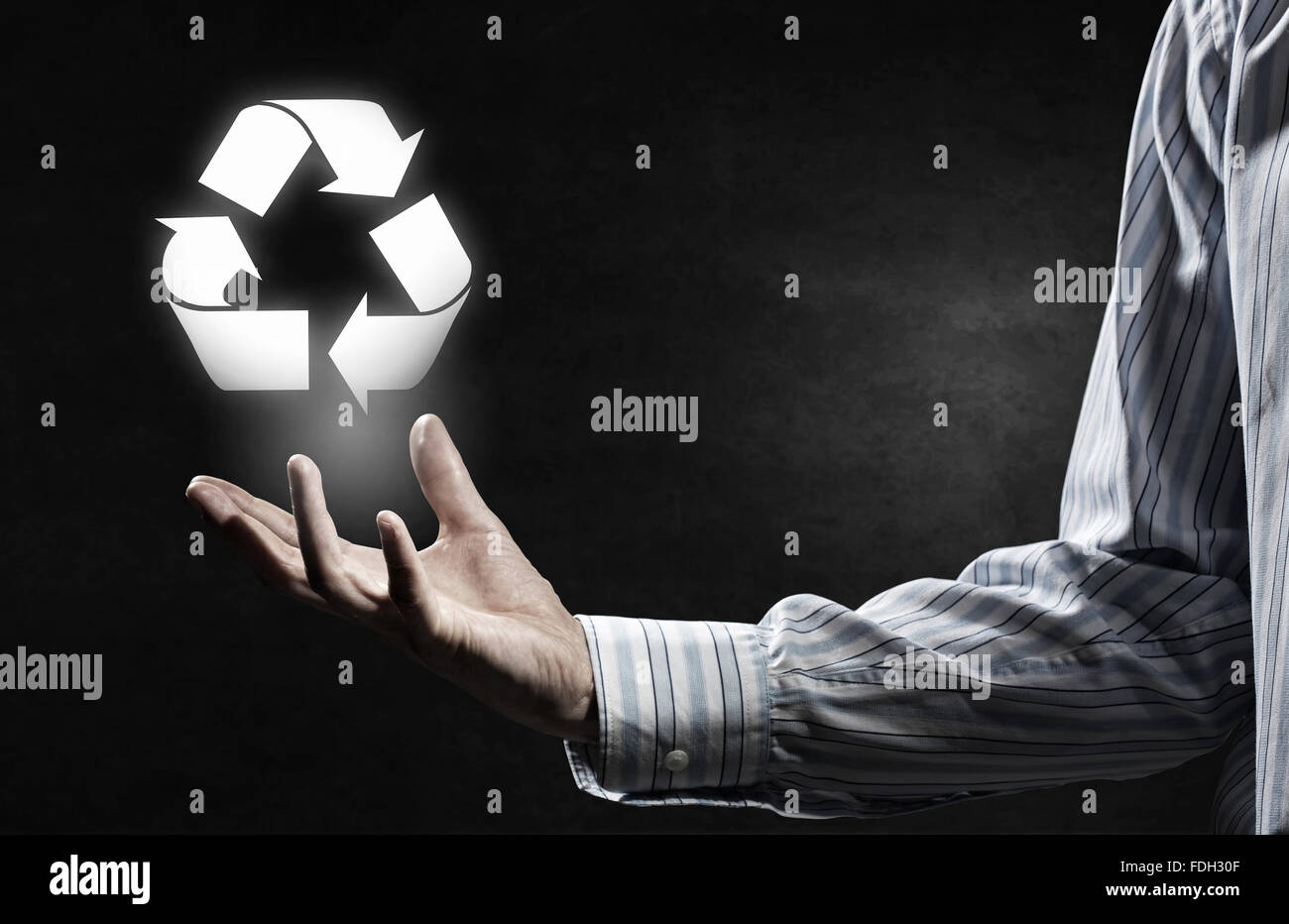 Hand of businessman on dark background holding recycling sign Stock ...