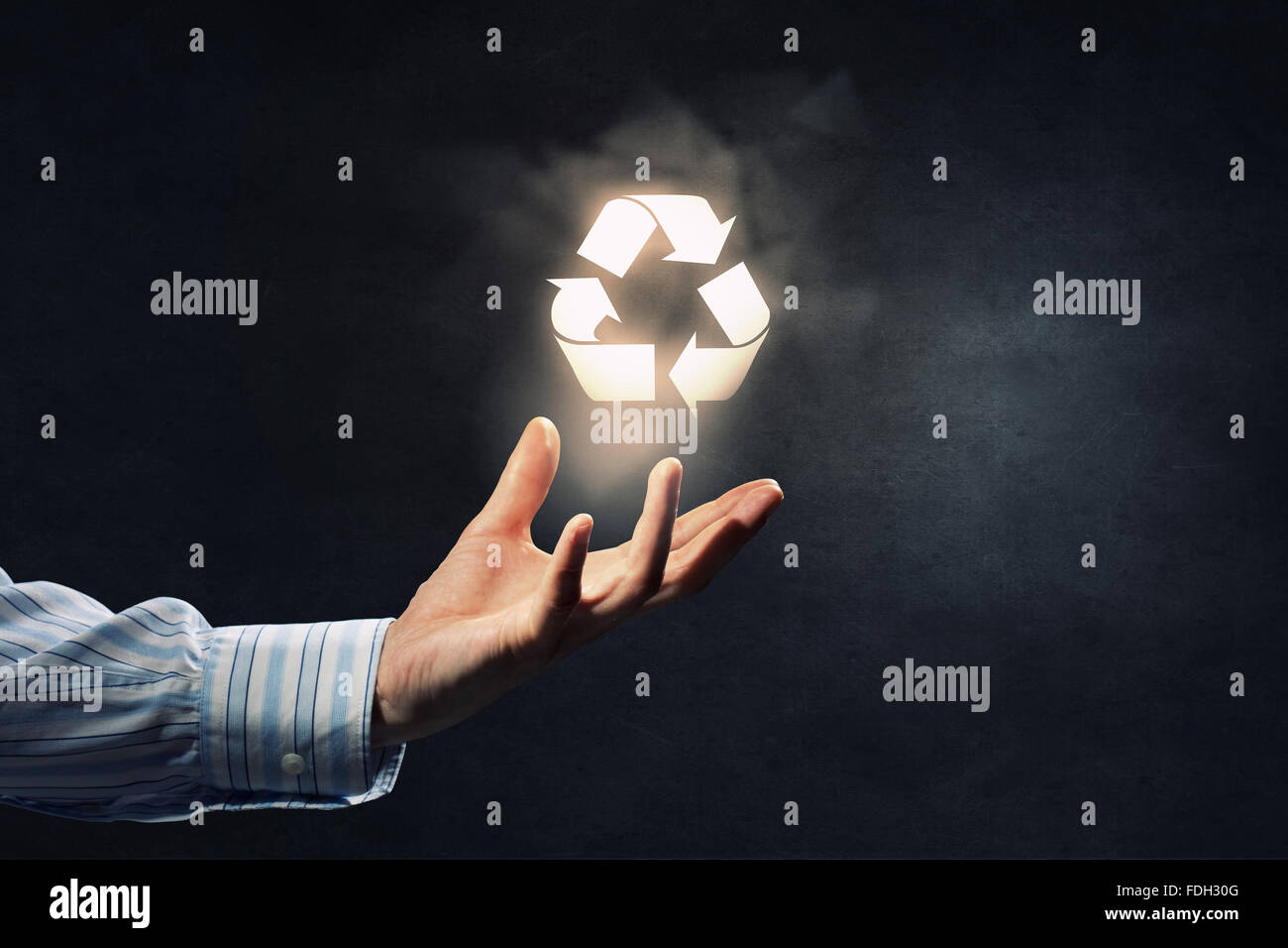 Hand of businessman on dark background holding recycling sign Stock ...