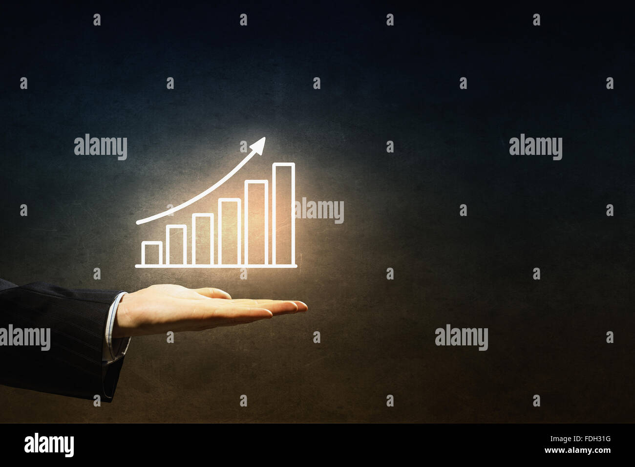 Hand of businessman on dark background showing glowing business growth ...