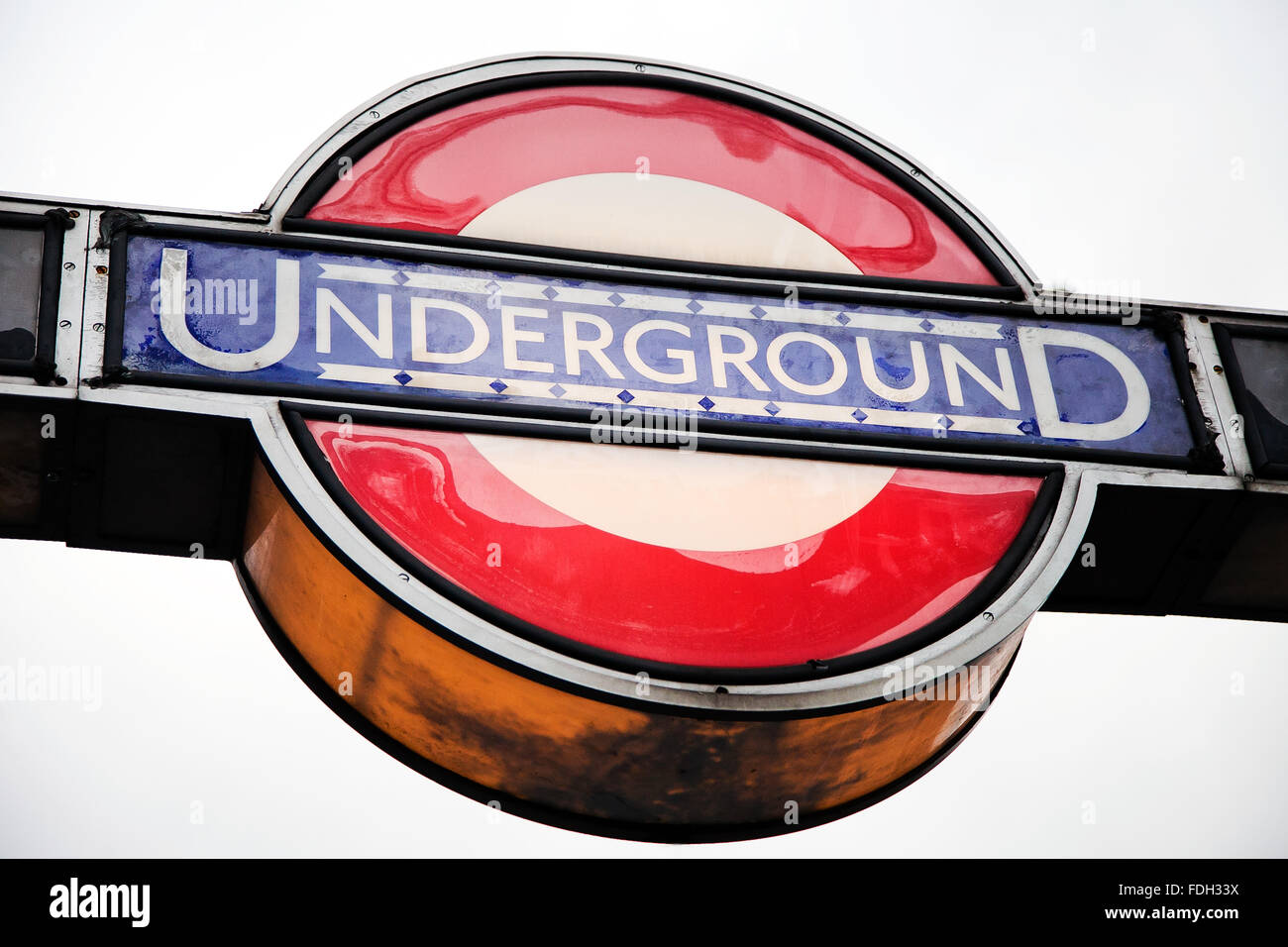 A close up of a London underground sign positioned next to public ...