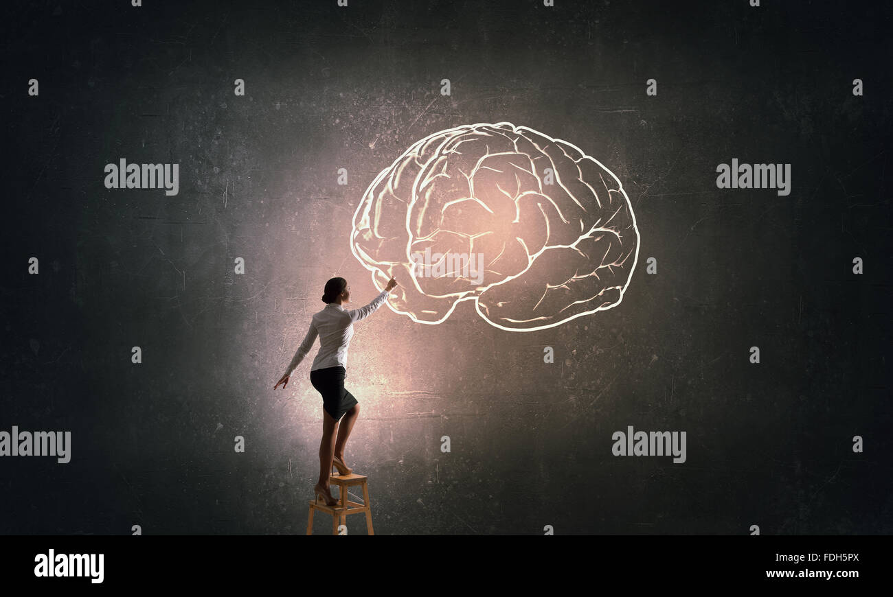 Businesswoman standing on chair and reaching brain concept above Stock ...