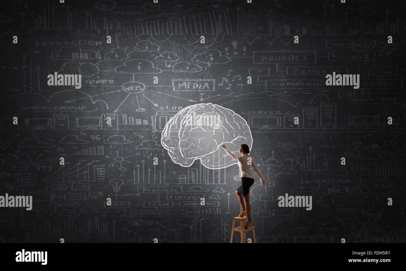 Businesswoman standing on chair and reaching brain concept above Stock ...
