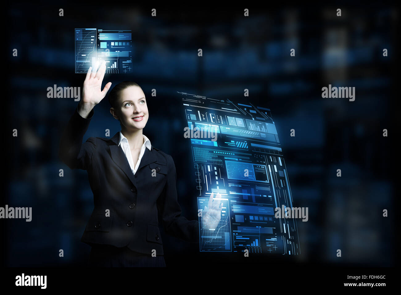 Attractive smiling businesswoman working with virtual panel interface ...