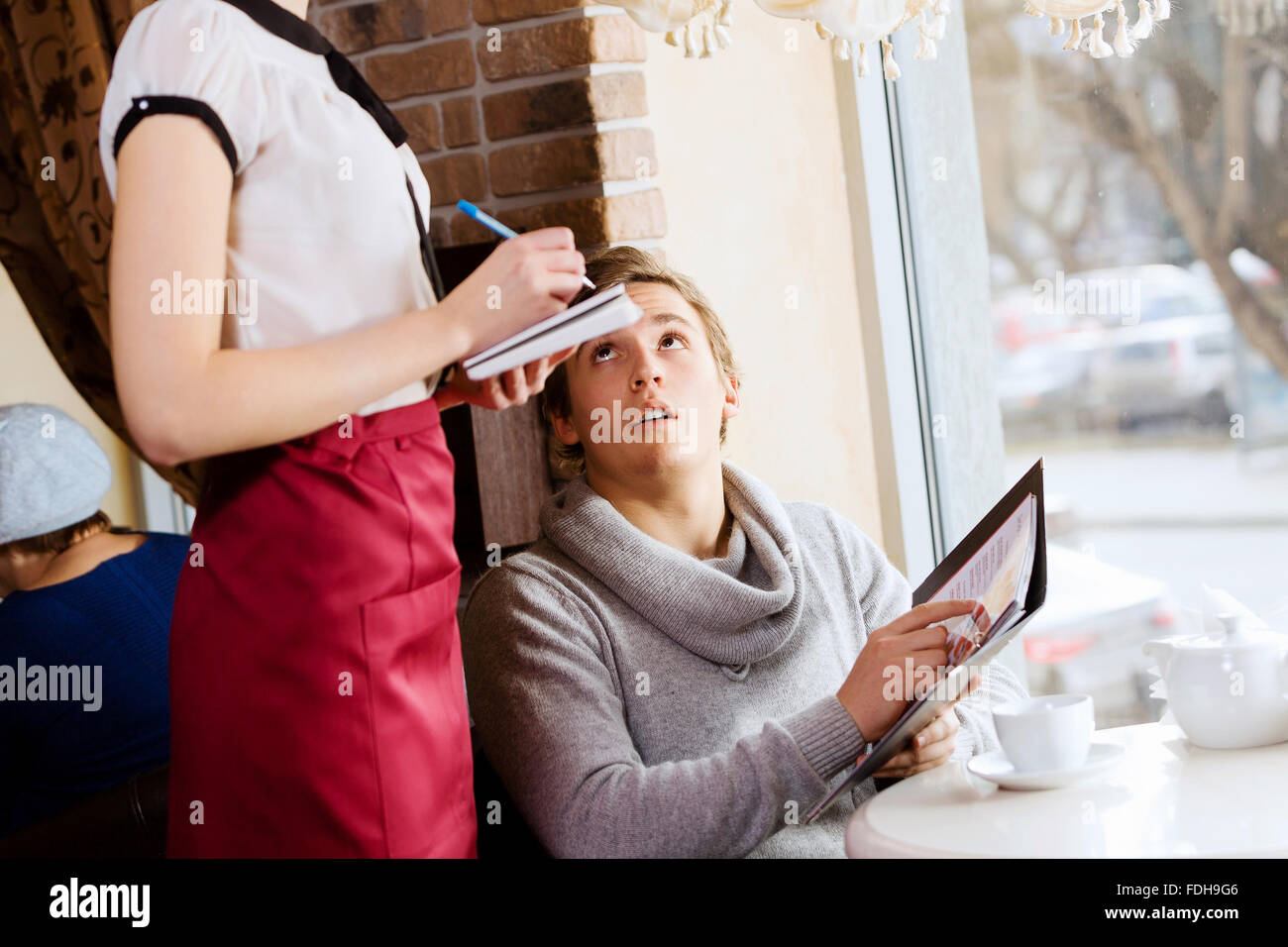 Young handsome man making order at restaurant Stock Photo - Alamy