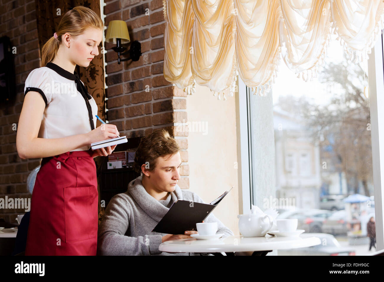 Young attractive woman making order at restaurant Stock Photo - Alamy