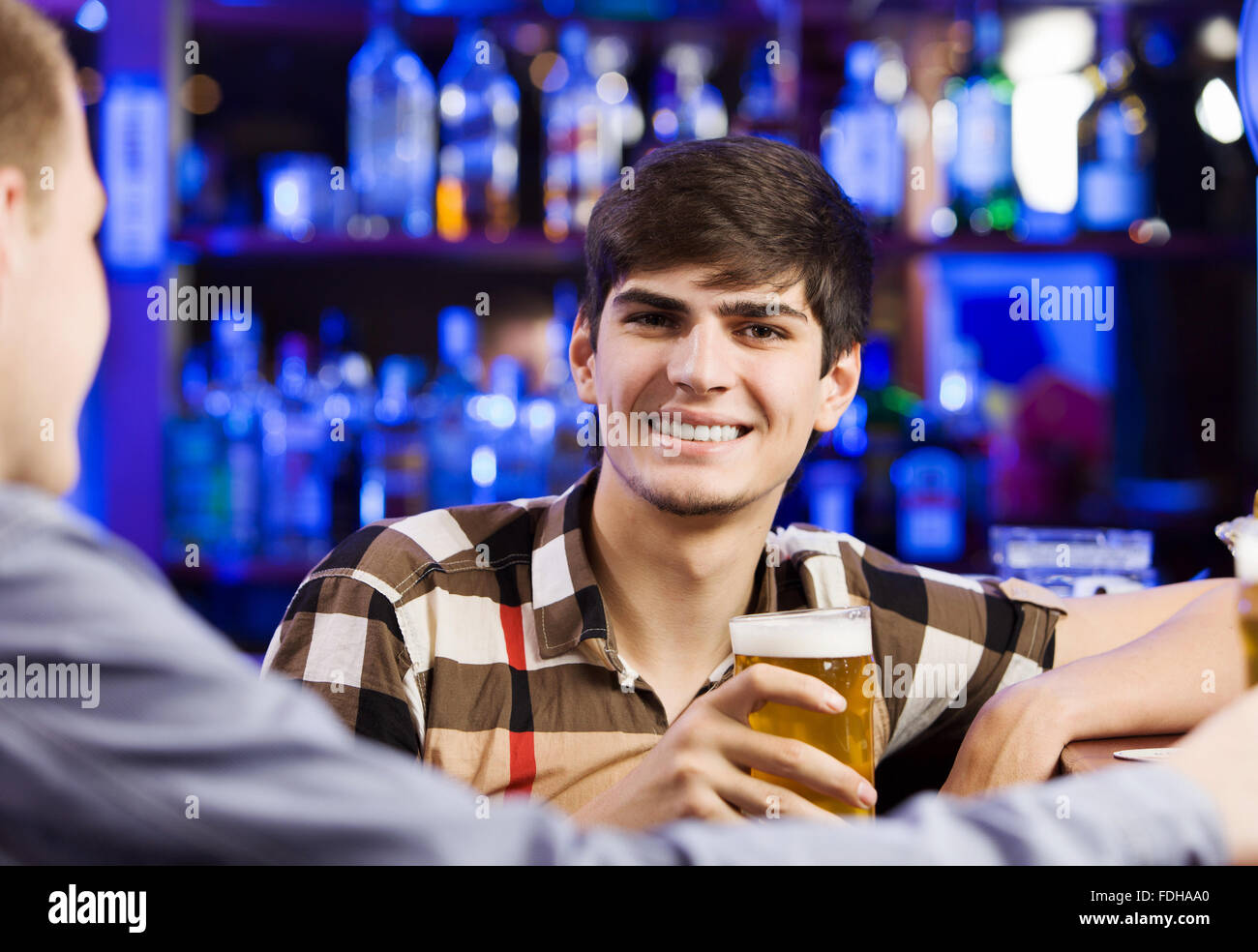 Two young men sitting at bar and talking Stock Photo - Alamy