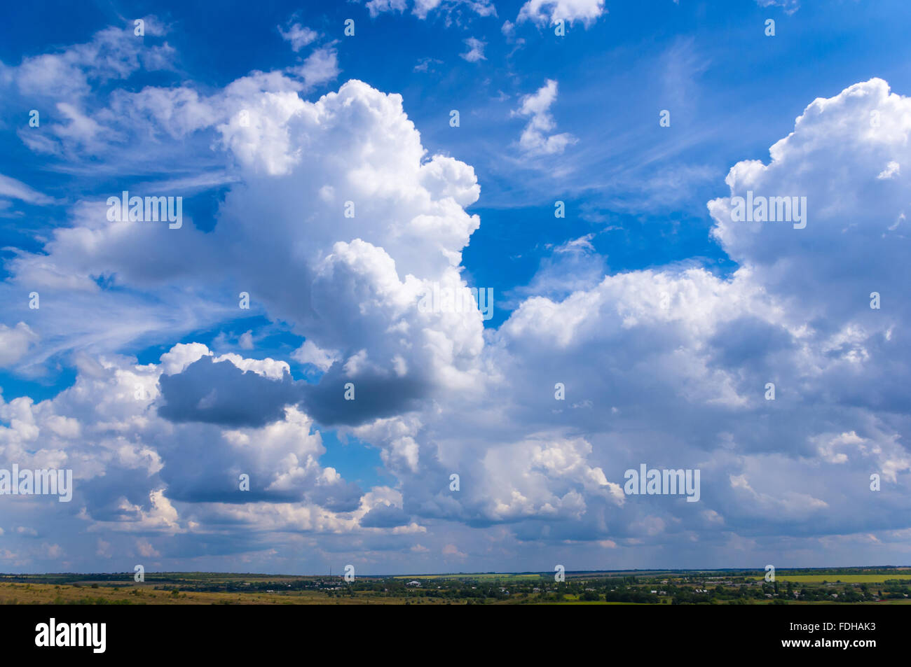 Summer landscape with green grass, village, fields and beautiful clouds ...