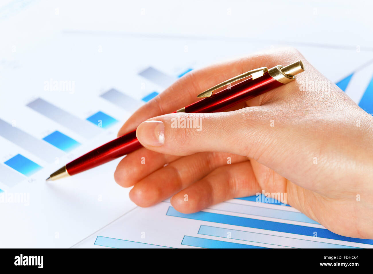 Close up of male hand holding pen pointing at graphs hi-res stock ...