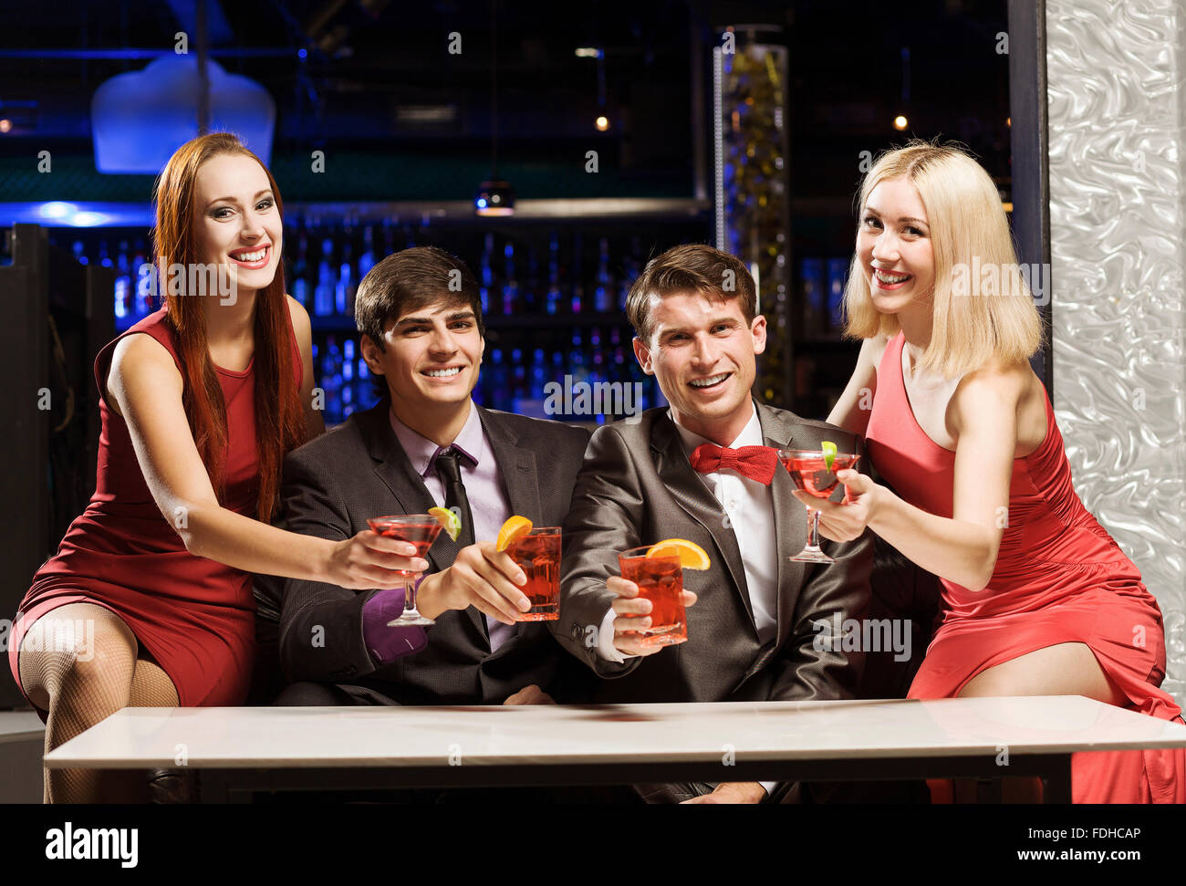 Young attractive people of four having cocktail party Stock Photo - Alamy