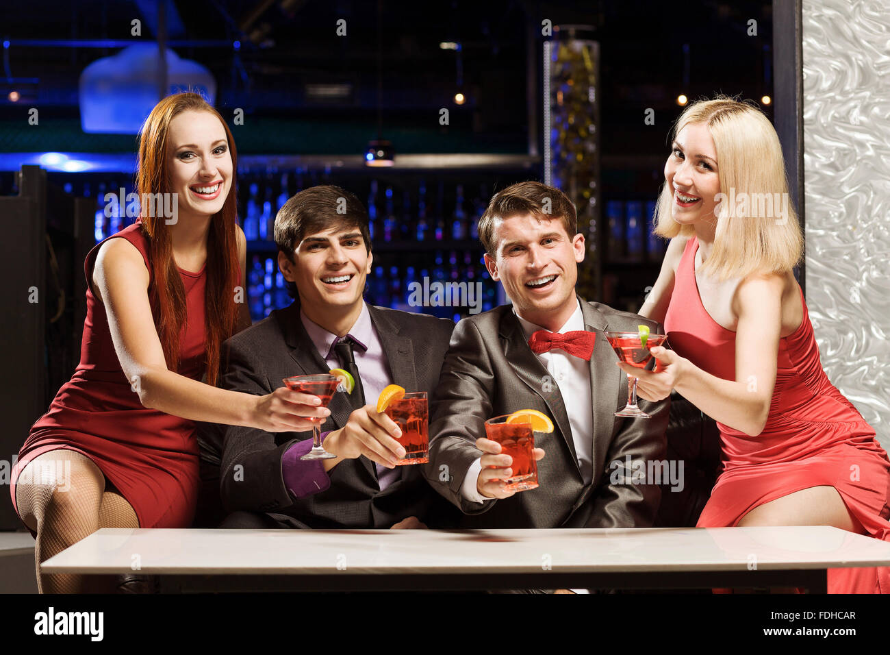 Young attractive people of four having cocktail party Stock Photo - Alamy