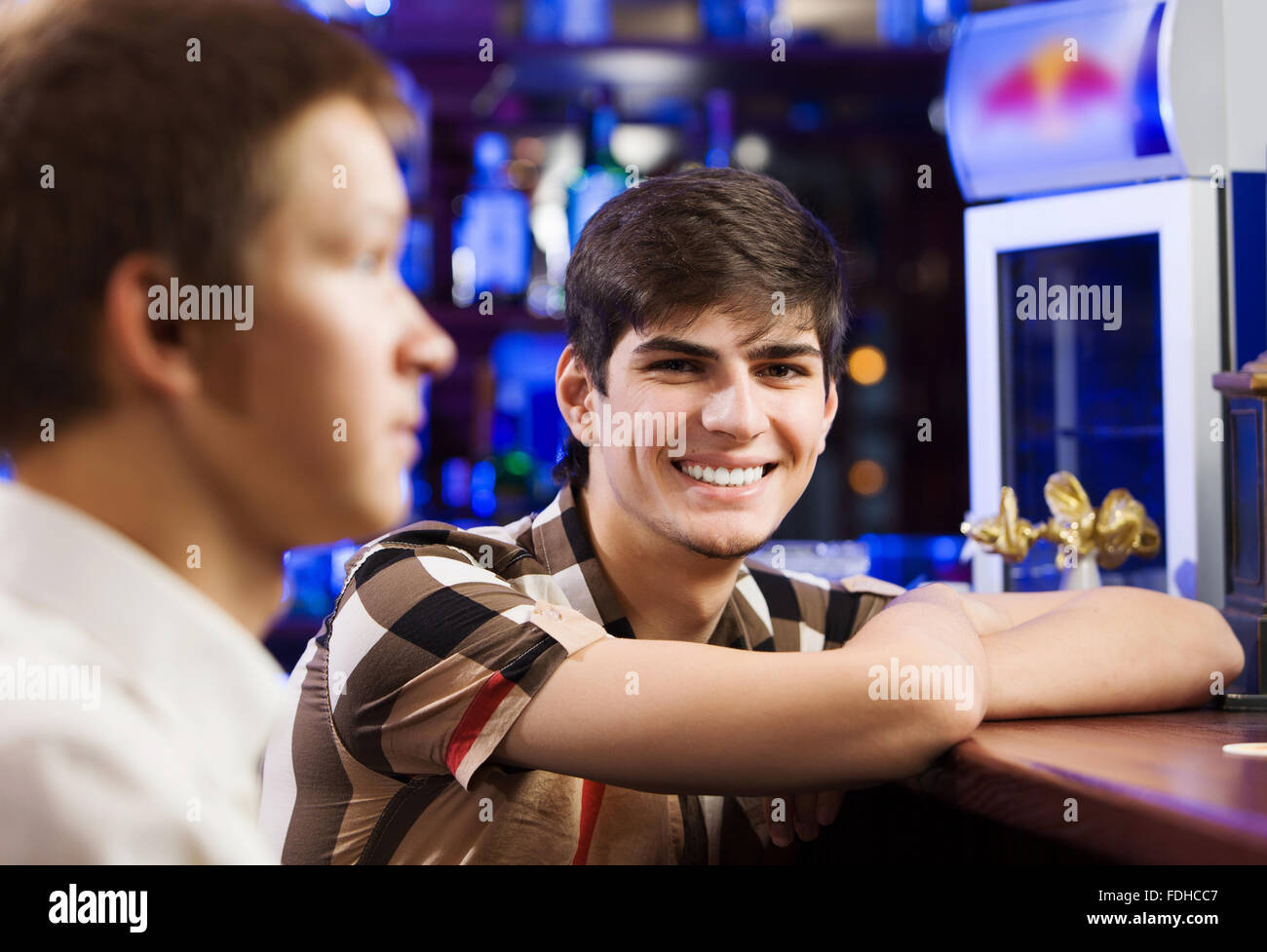 Two young men sitting at bar and talking Stock Photo - Alamy