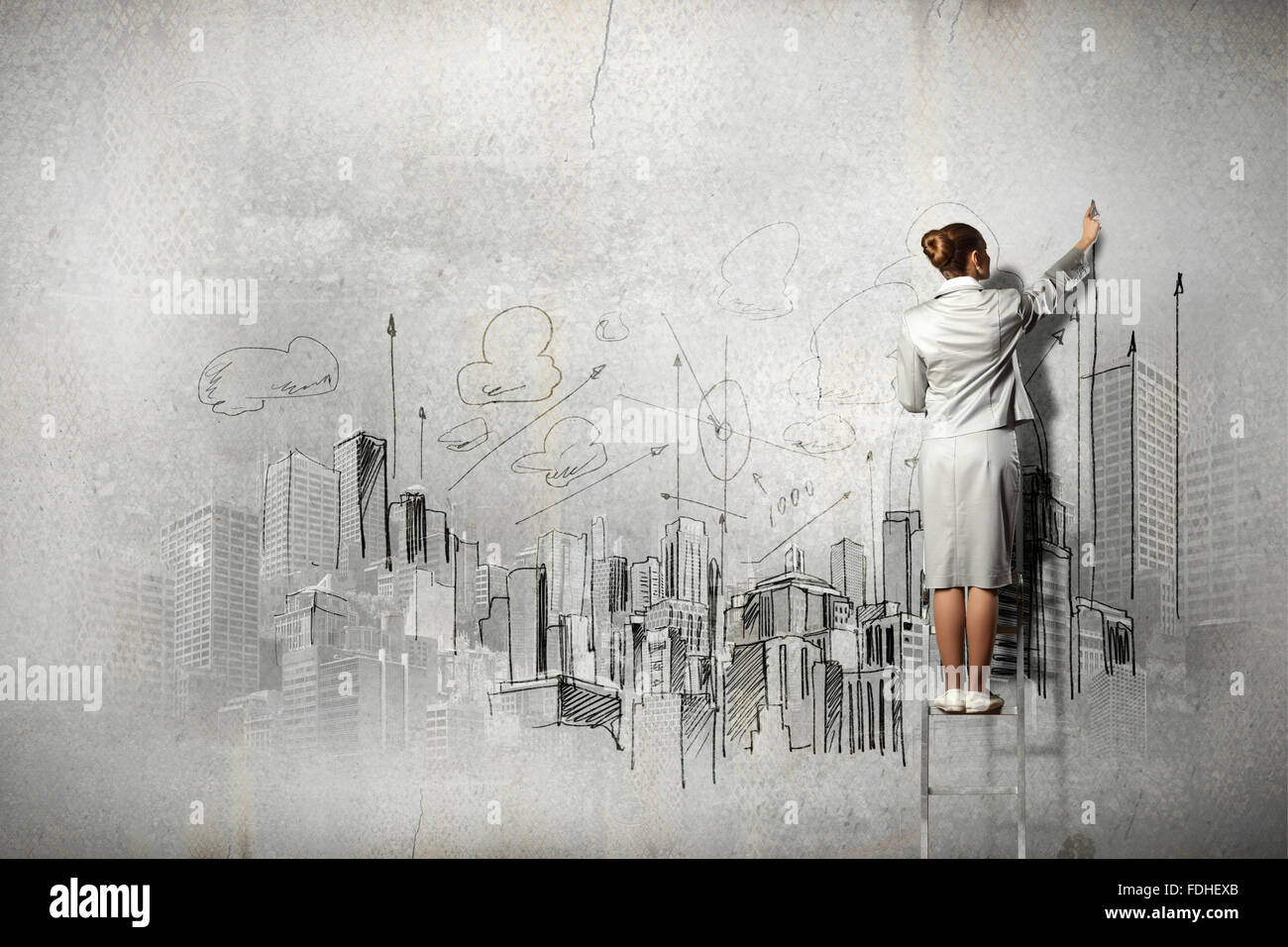 Businesswoman standing on ladder and drawing sketch on wall Stock Photo ...