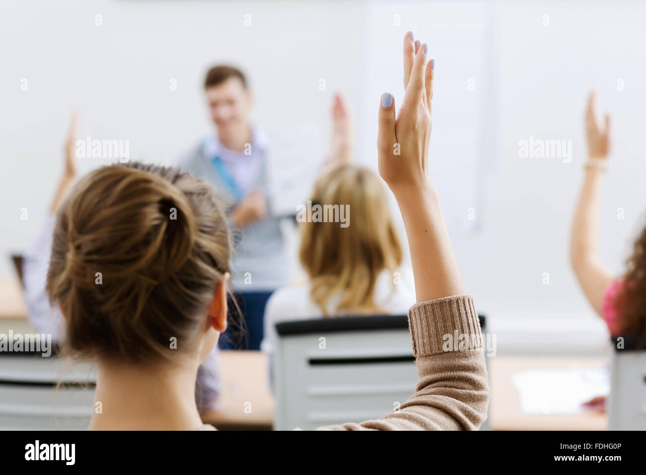 Young teacher in classroom standing in front of class Stock Photo - Alamy