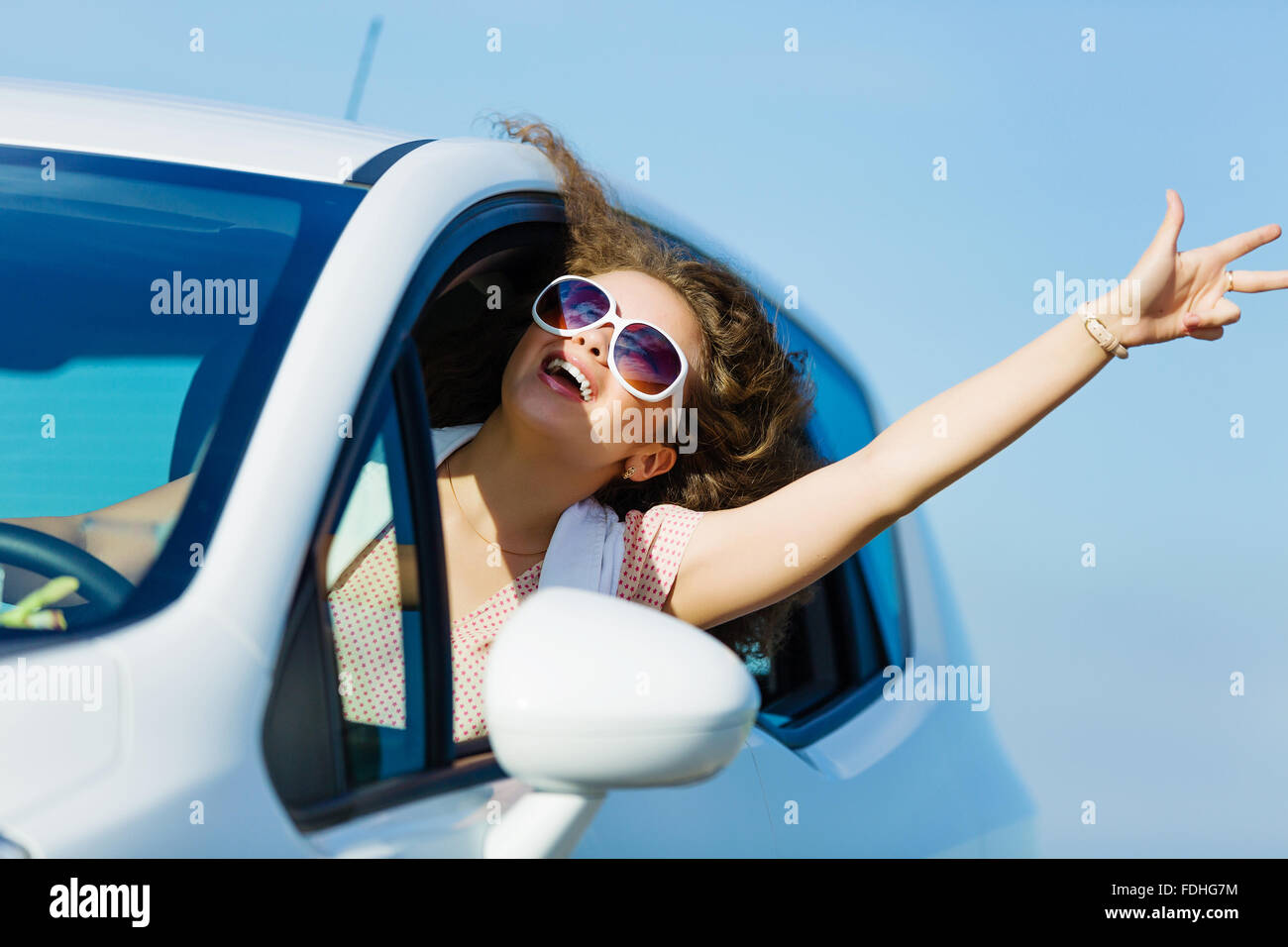 Young pretty woman driving car and leaning out of car window Stock ...