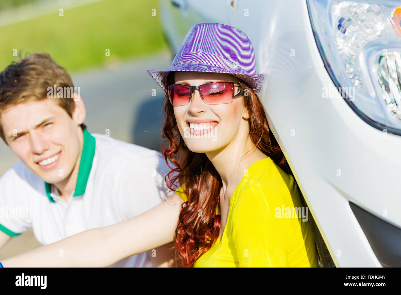 Young people sitting near car aside of road Stock Photo - Alamy