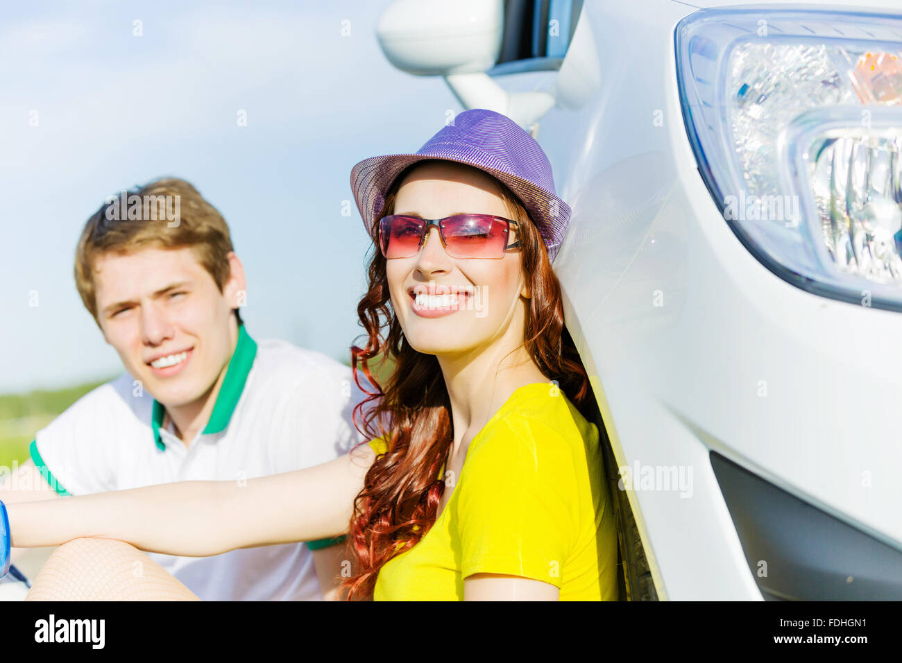 Young people sitting near car aside of road Stock Photo - Alamy